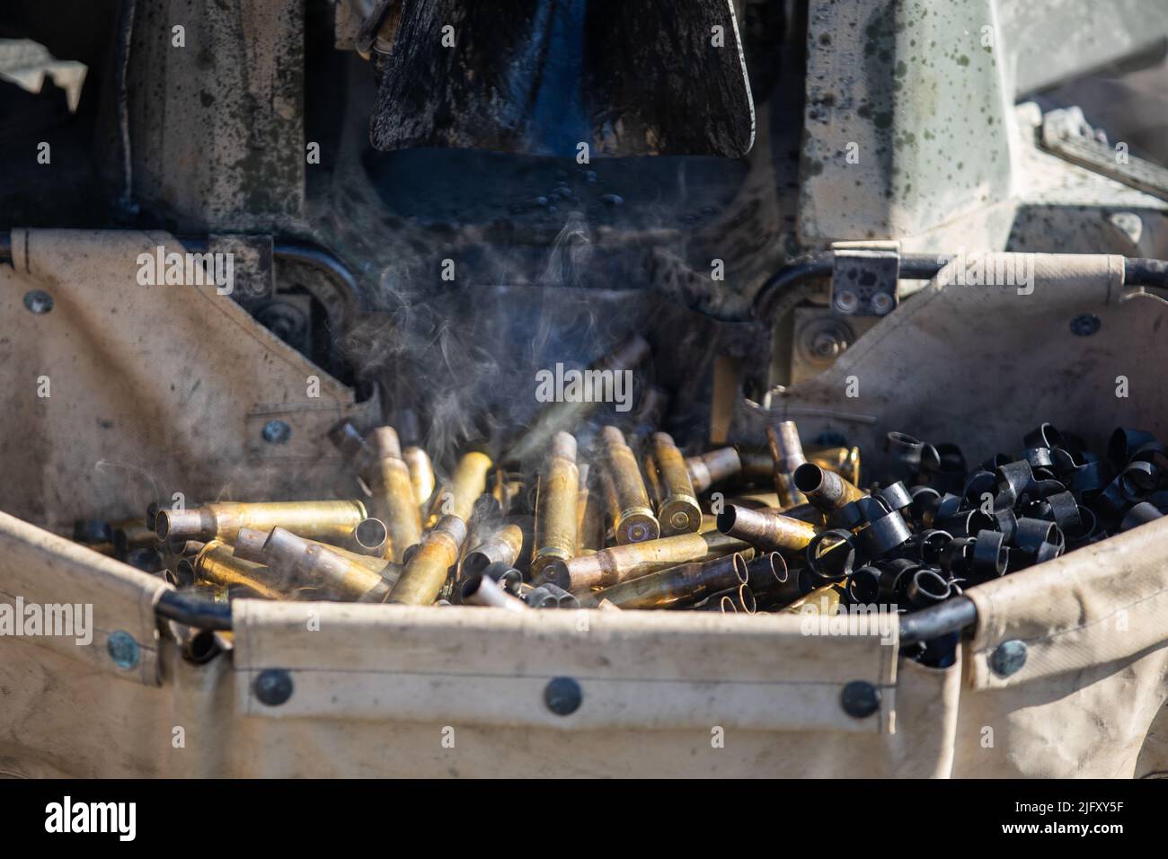 A pile of .50 caliber brass collects in a basket underneath a Common ...