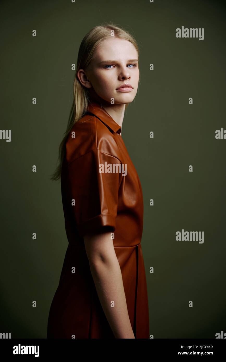 Self-confident fashionable blonde young model looking over her shoulder ...