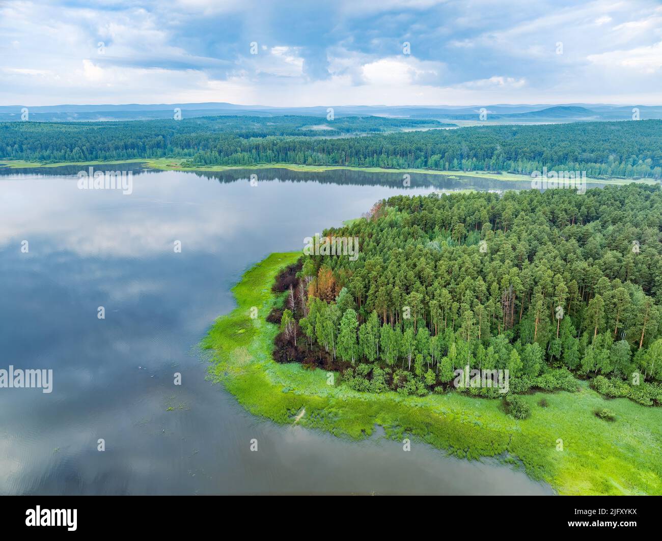 Big lake with green shores in bright sun light, aerial landscape ...