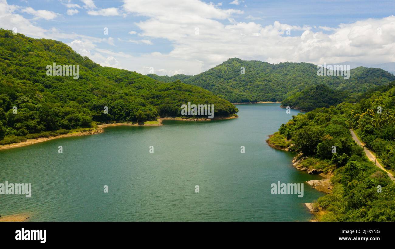 Lake among the mountains covered with jungle. Victoria Reservoir, Sri ...
