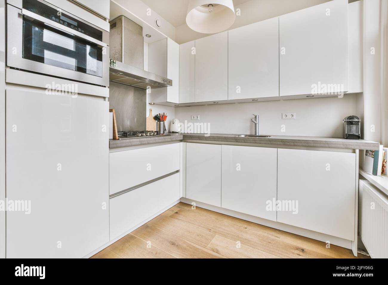 Fragment of interior of light narrow home kitchen with minimalist style ...