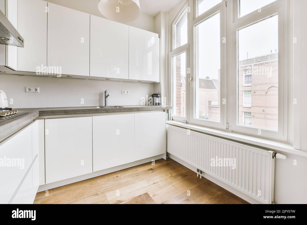 Fragment of interior of light narrow home kitchen with minimalist style ...