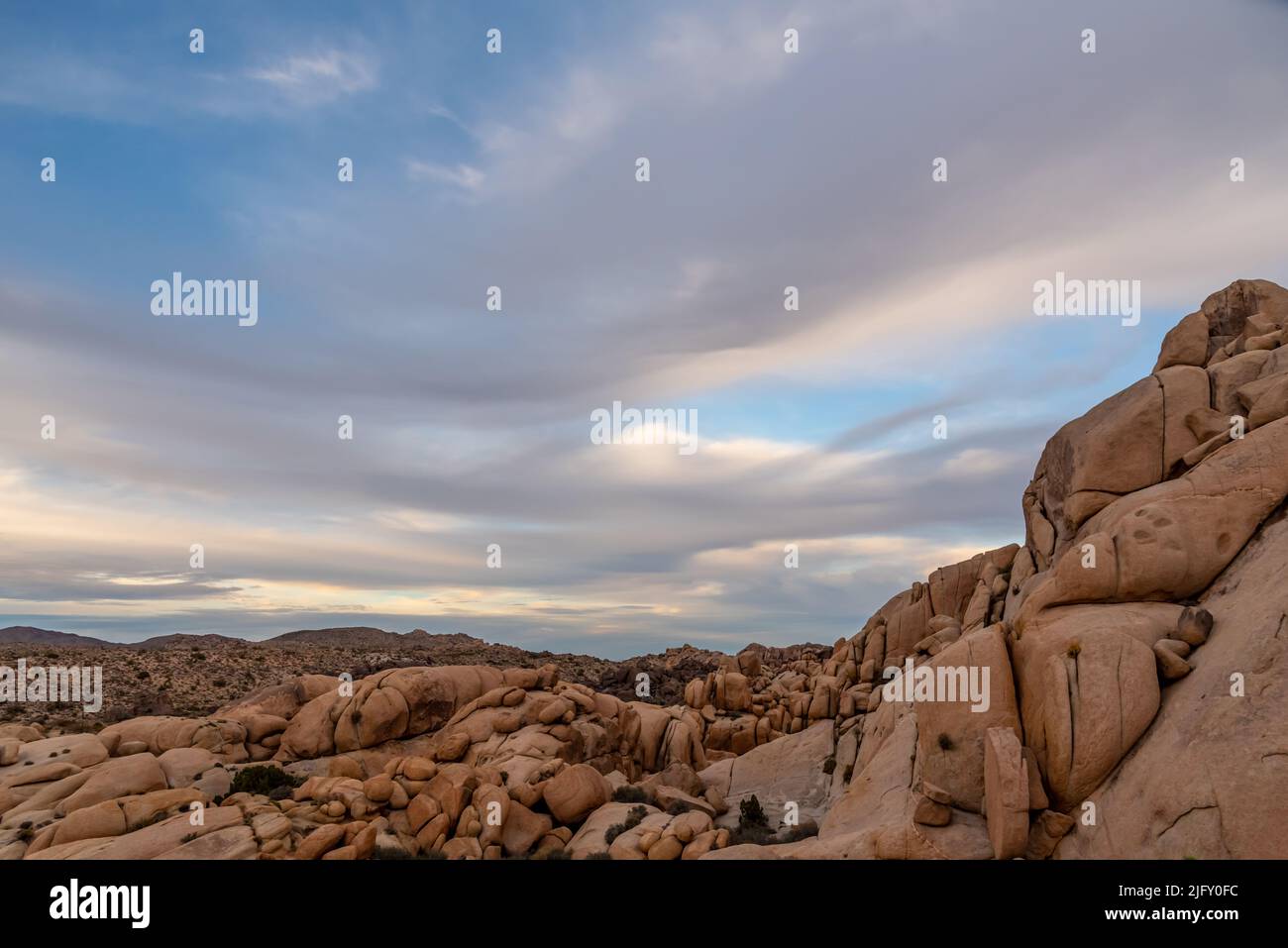 Landscape scenery with pastel pink sunset behind rock boulders in ...