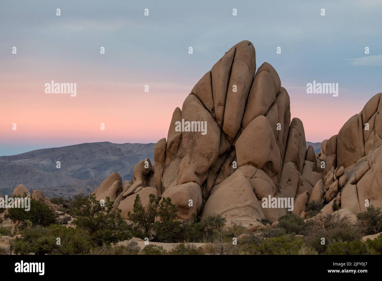 Landscape scenery with pastel pink sunset behind rock boulders in ...