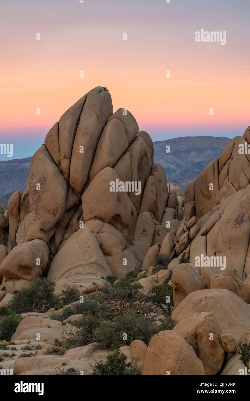 Landscape scenery with pastel pink sunset behind rock boulders in ...