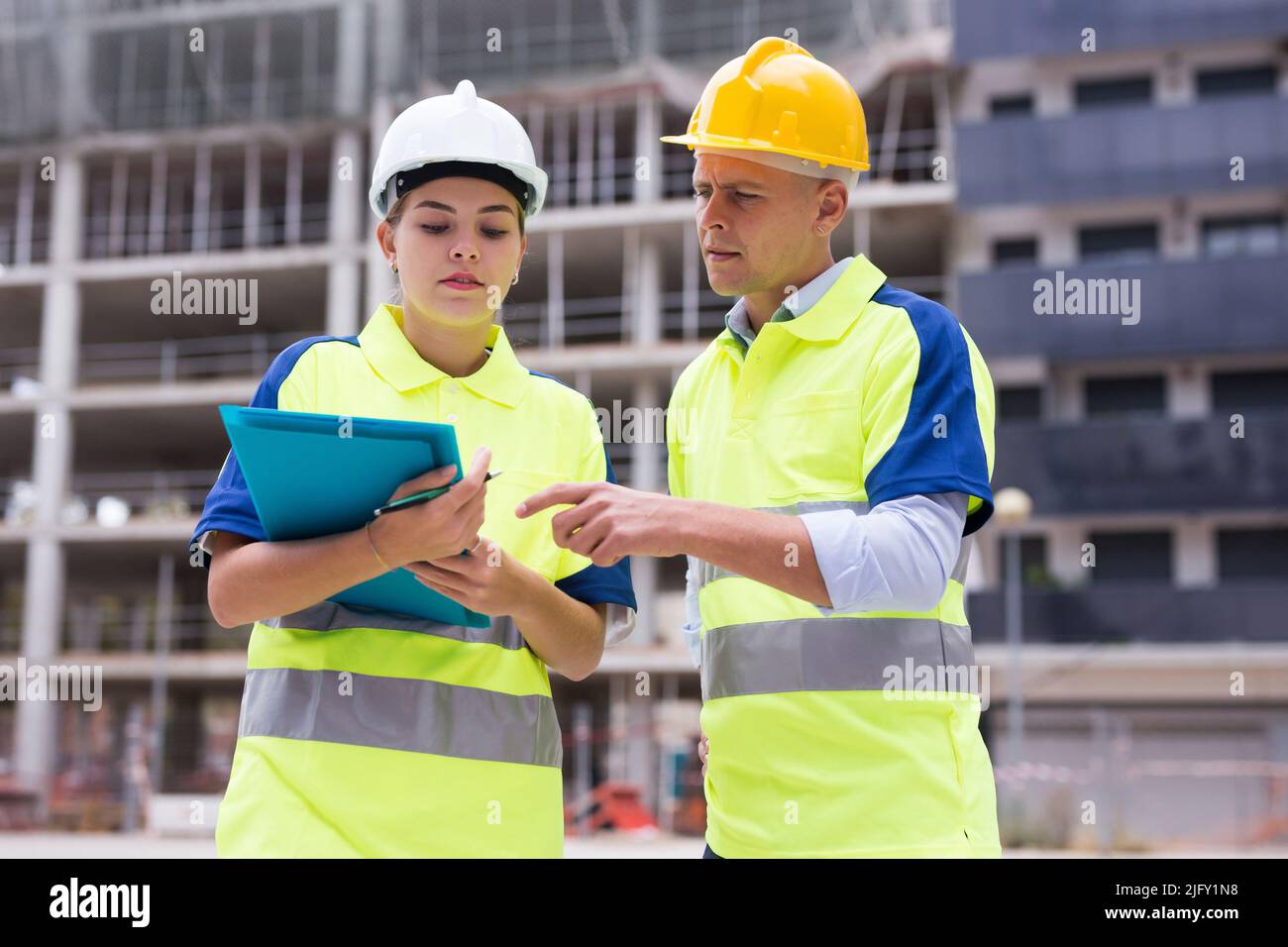 Man and woman engineers in construction site Stock Photo - Alamy