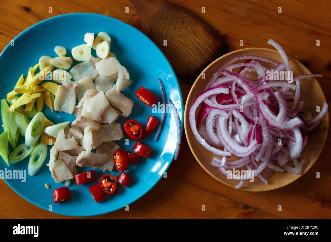 In the blue plate, there is hot water blanched pork, sliced and chopped ...