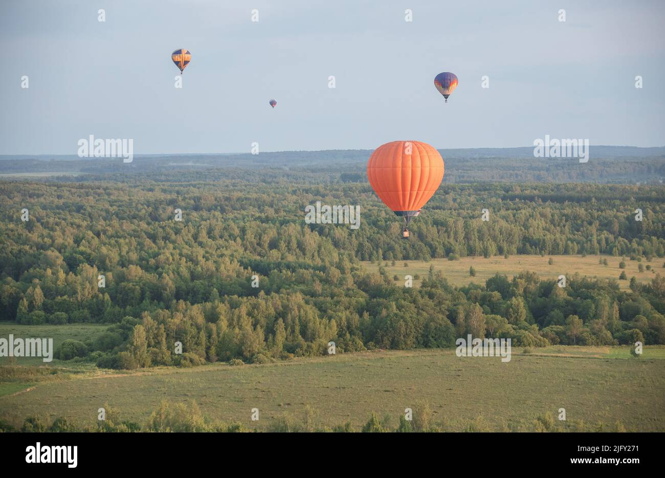 Colorful air balloons flying over the field using heat technology Stock ...