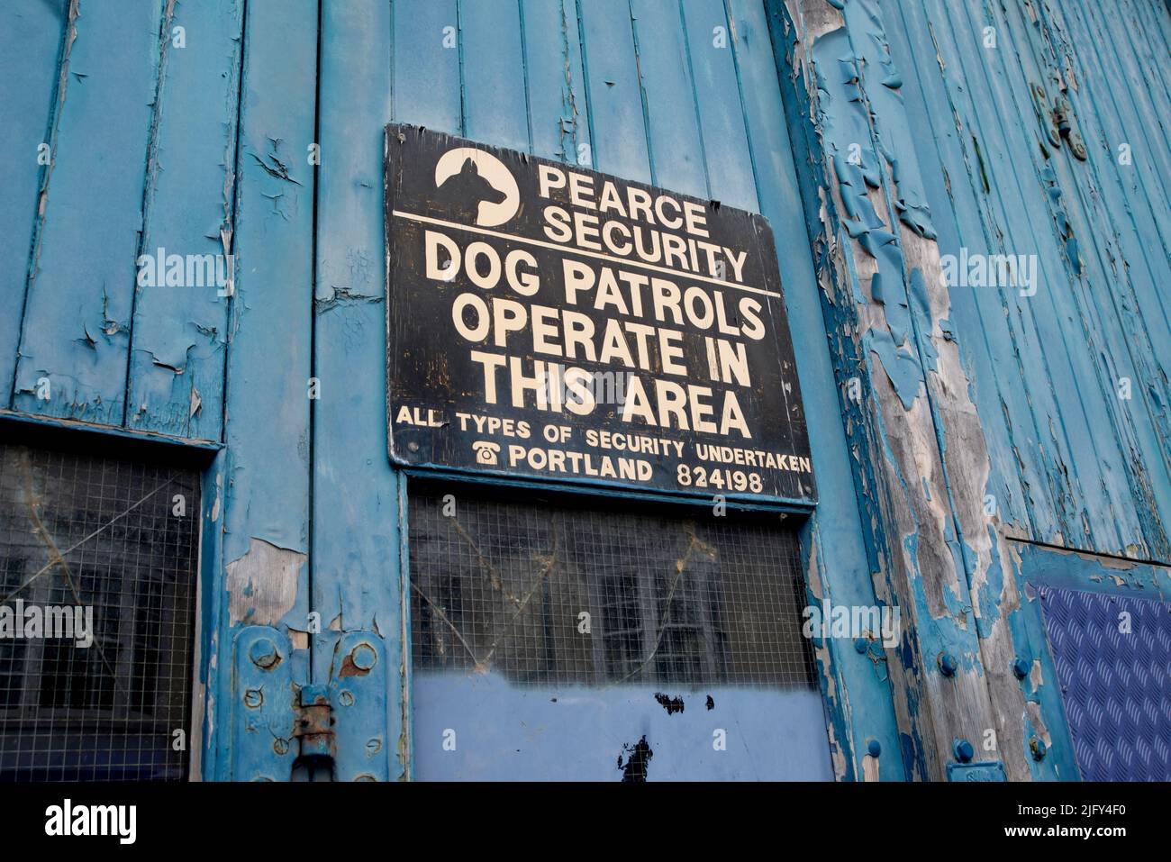 Dog patrol security sign on doors of warehouse building, Weymouth ...