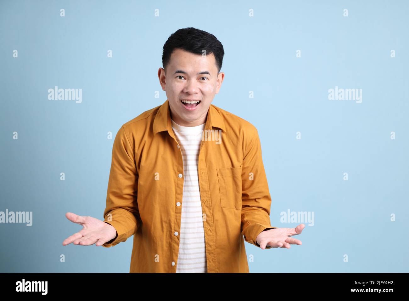 The Asian LGBTQ man with yellow shirt standing on the blue background ...