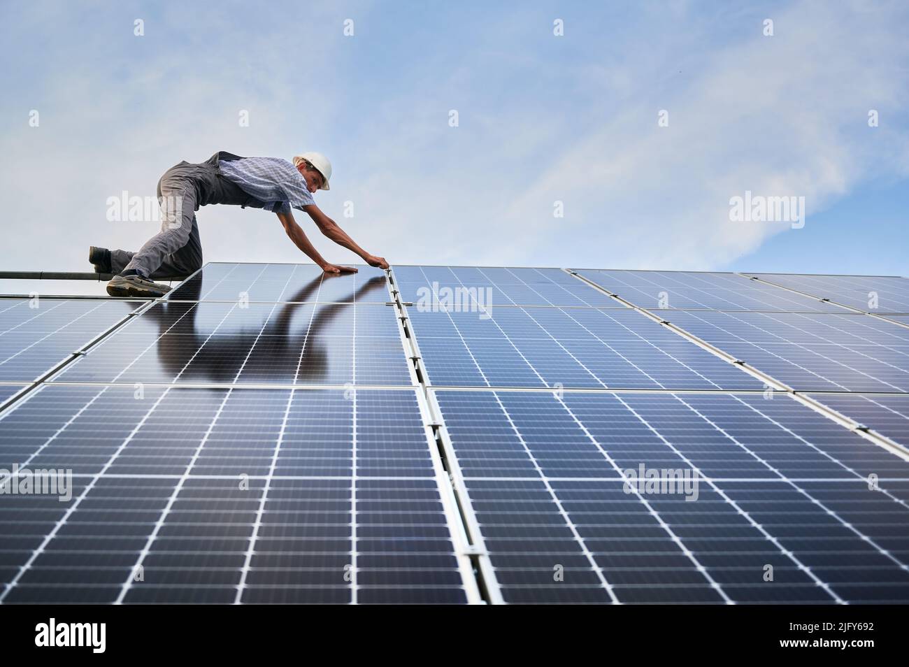 Male worker mounting photovoltaic solar panel system outdoors. Man ...