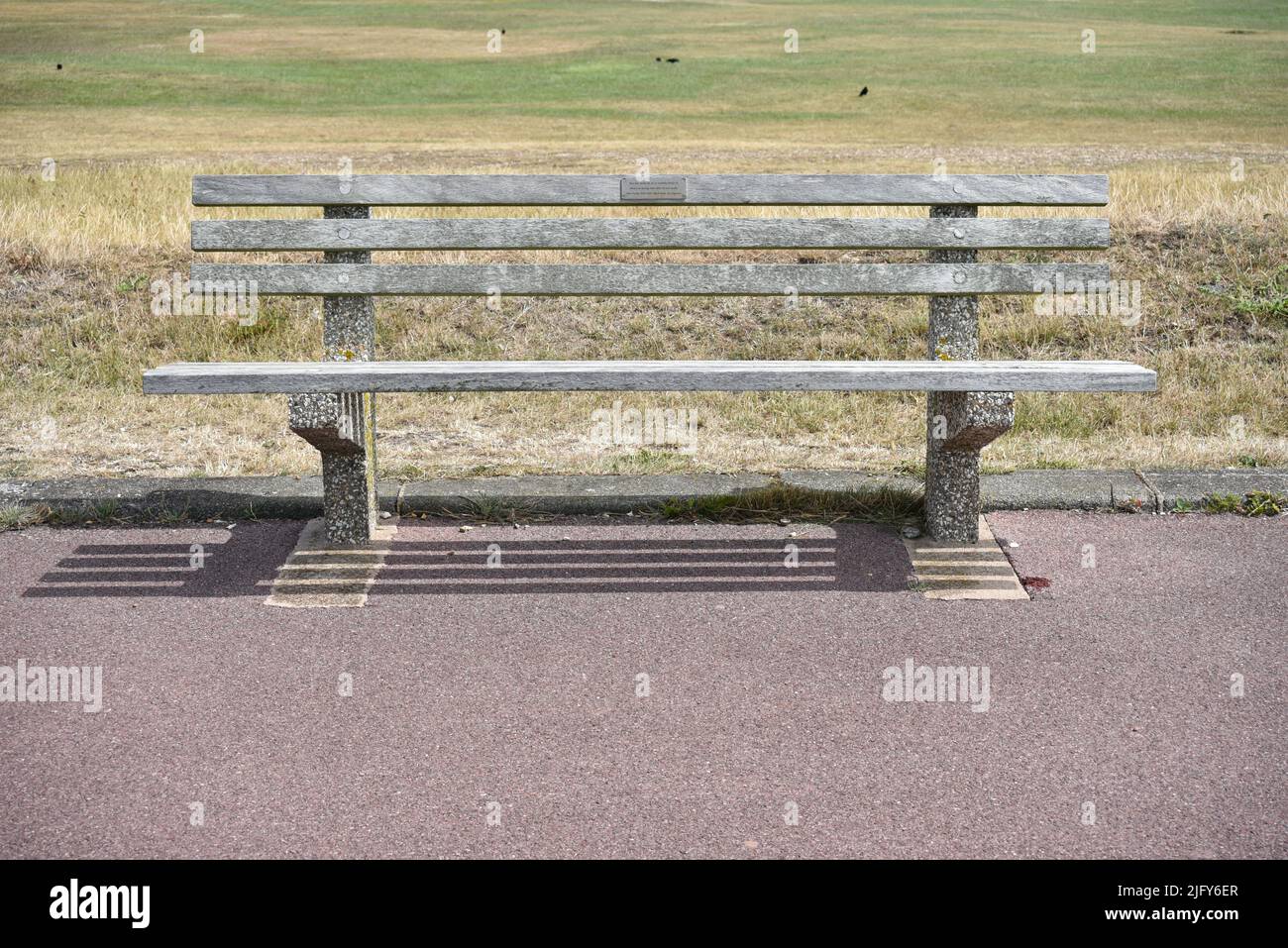 Wooden bench on the seafront of Stokes bay, Gosport. Plaque on it to ...