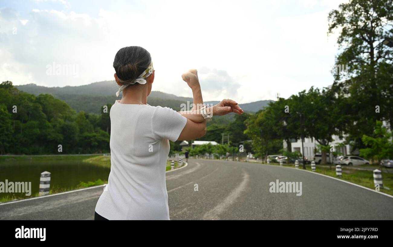 Active healthy middle aged woman stretching arm, warming up before ...