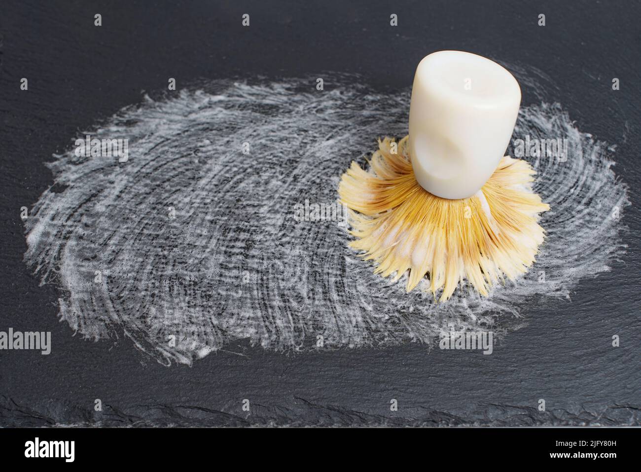 Lathering a shaving cream with a brush making circular movements on ...