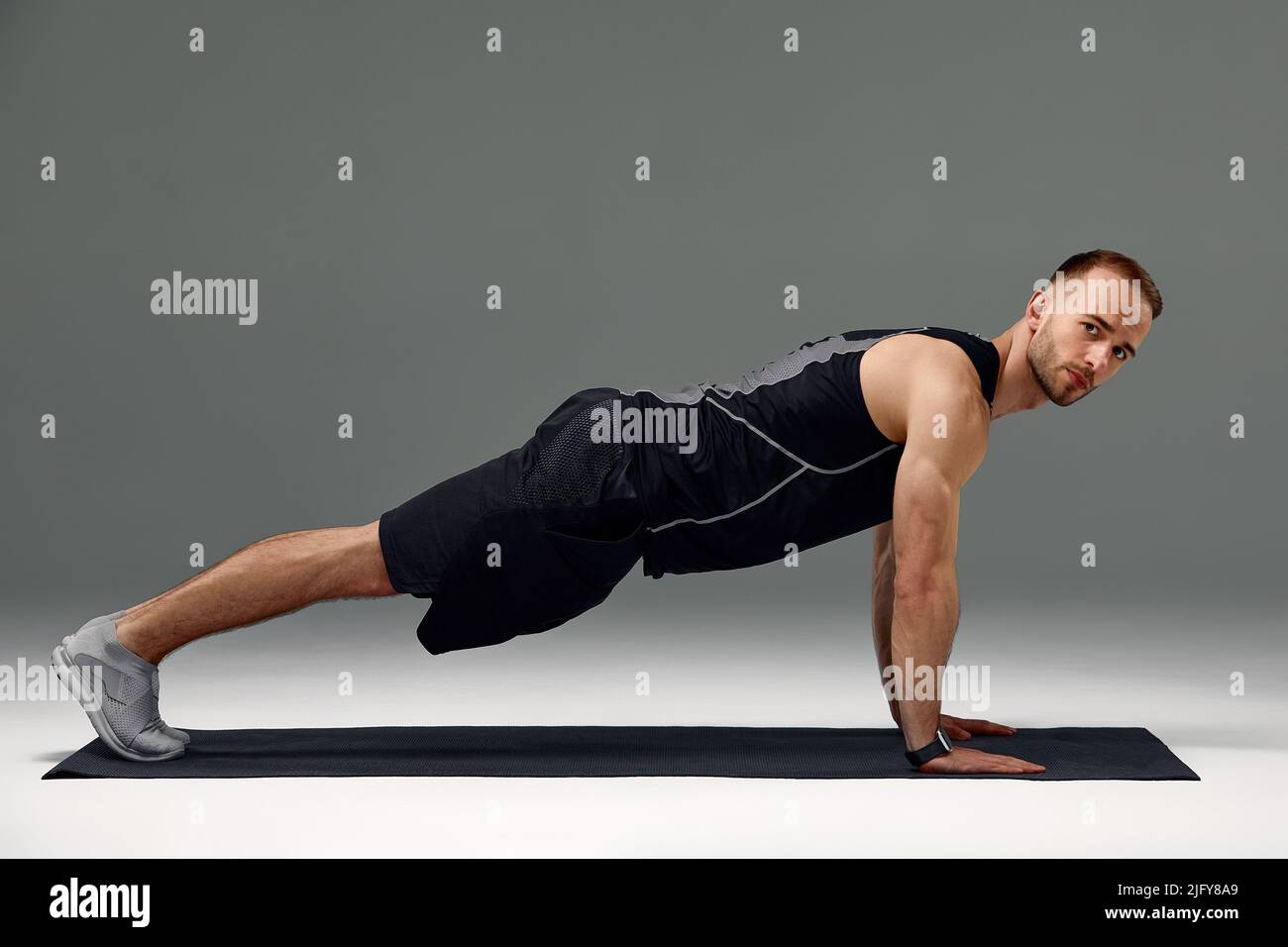 Handsome man doing plank exercise on floor indoors Stock Photo - Alamy