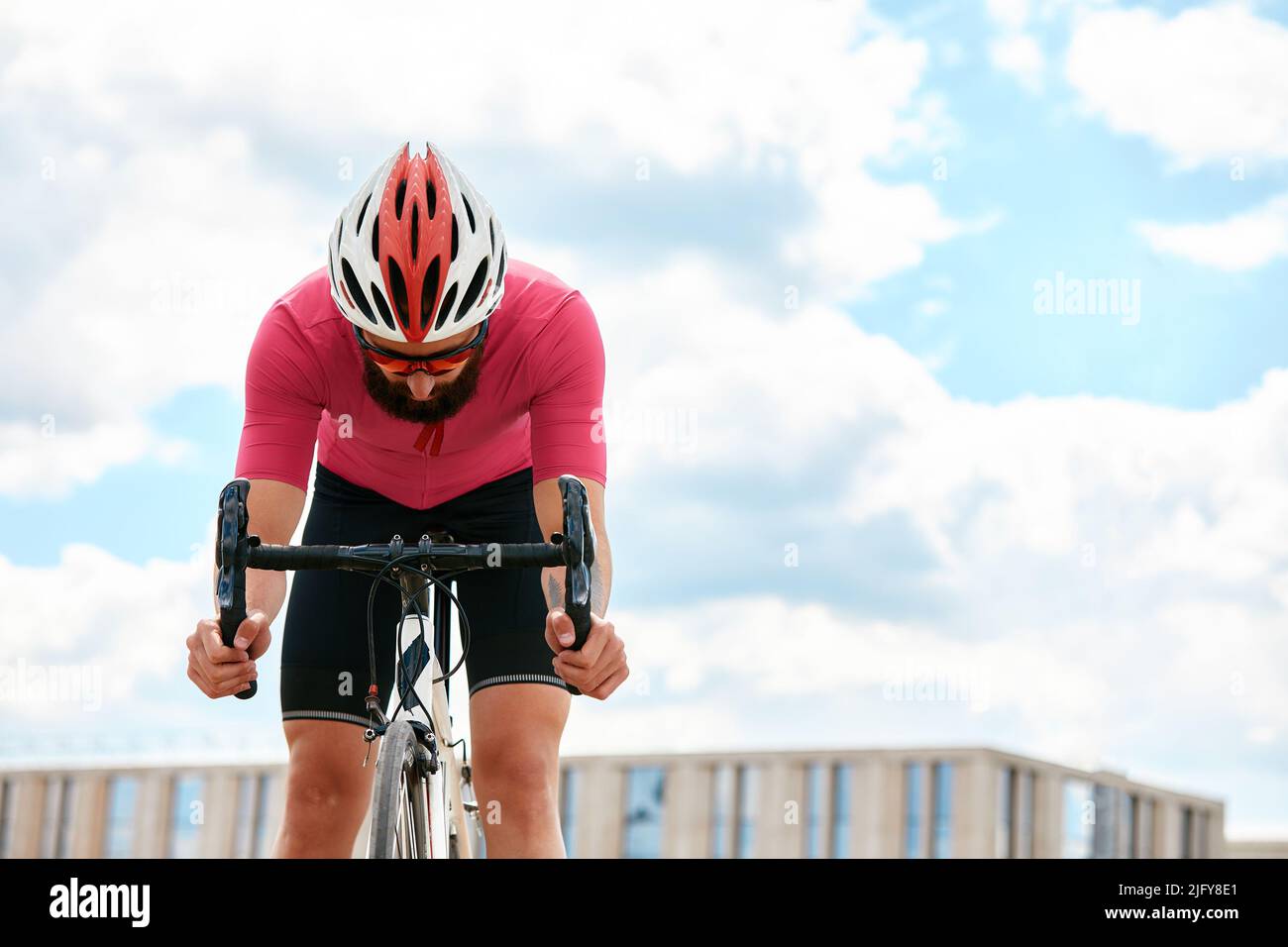 Strong Male cyclist in sportswear, glasses and protective helmet ...