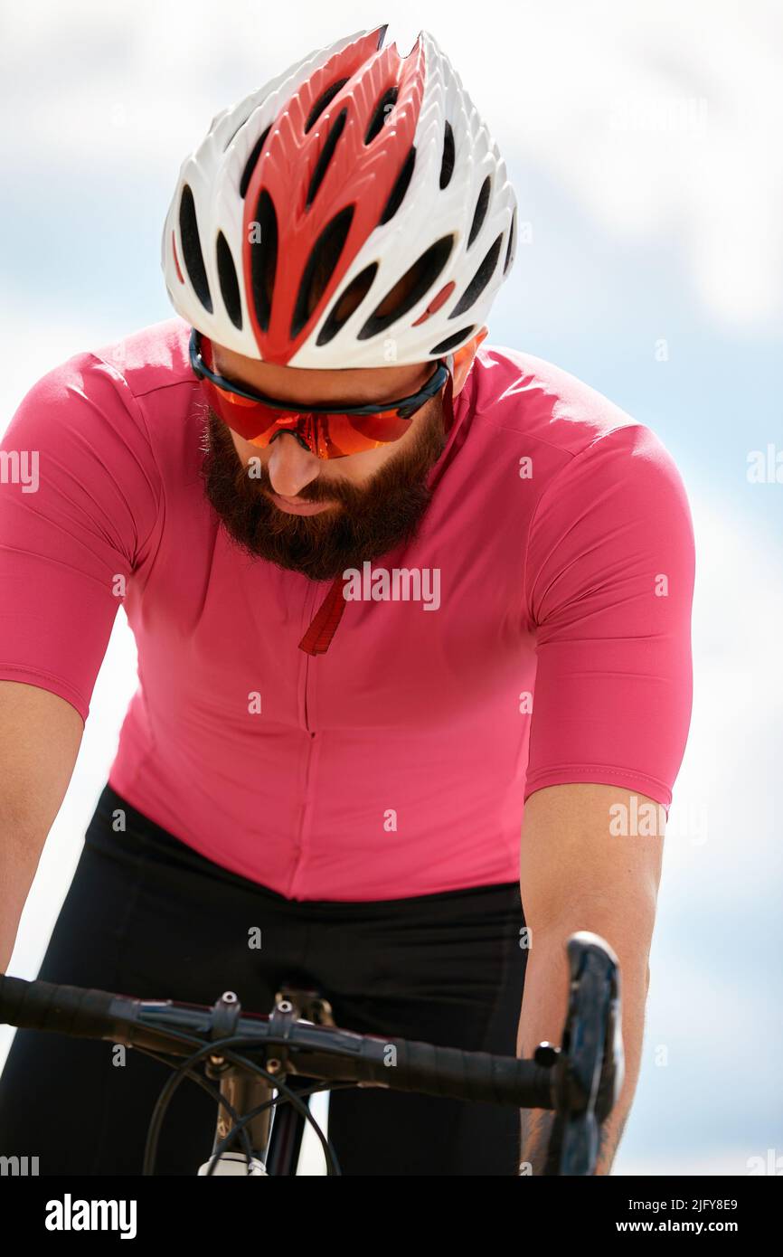 Strong Male cyclist in sportswear, glasses and protective helmet ...