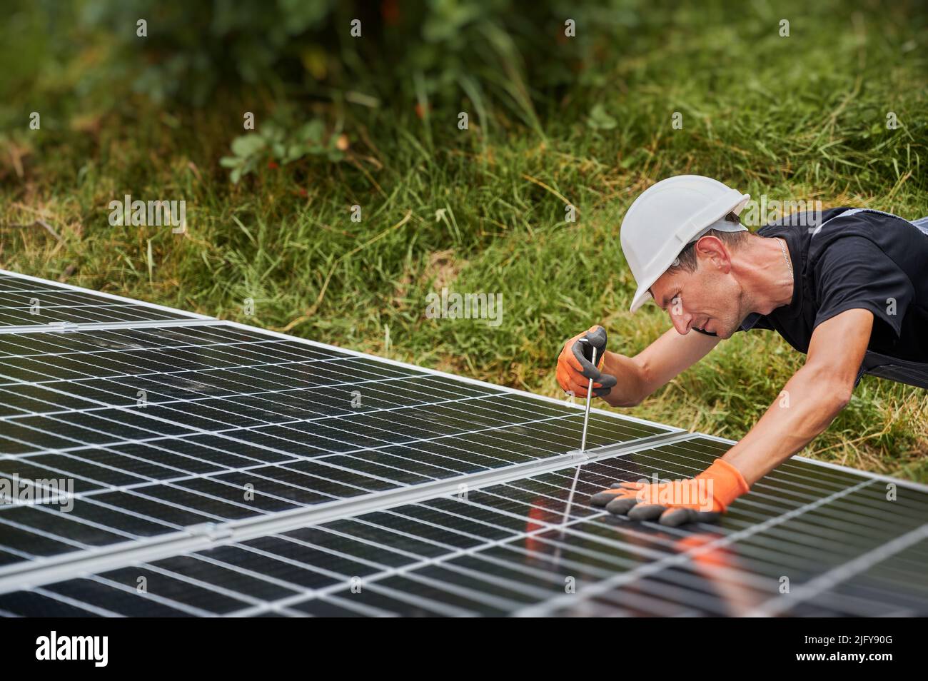 Worker installing photovoltaic solar panel system outdoors. Man ...