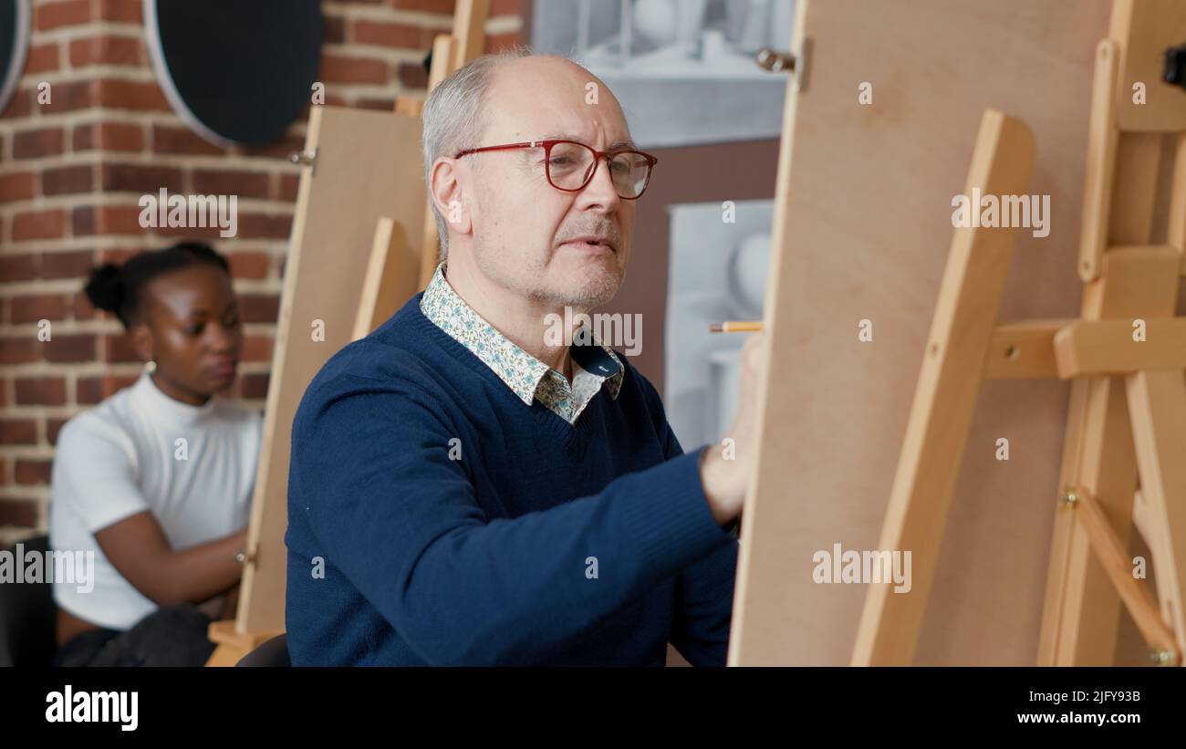 Senior art student creating professional drawing at workshop practice ...