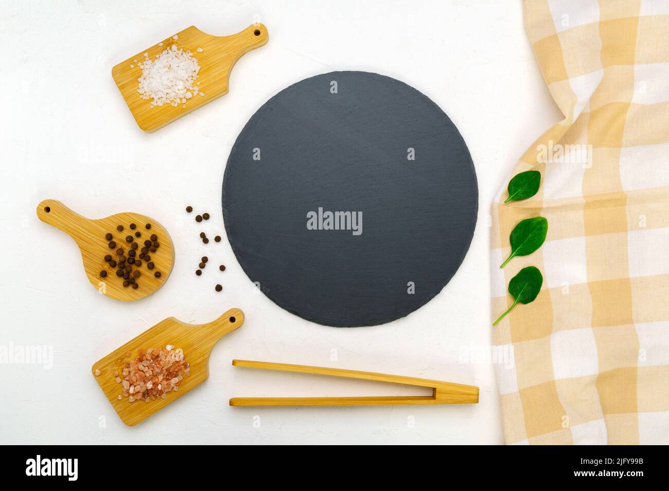 Black slate ingredients on a white concrete background. Copy the place ...