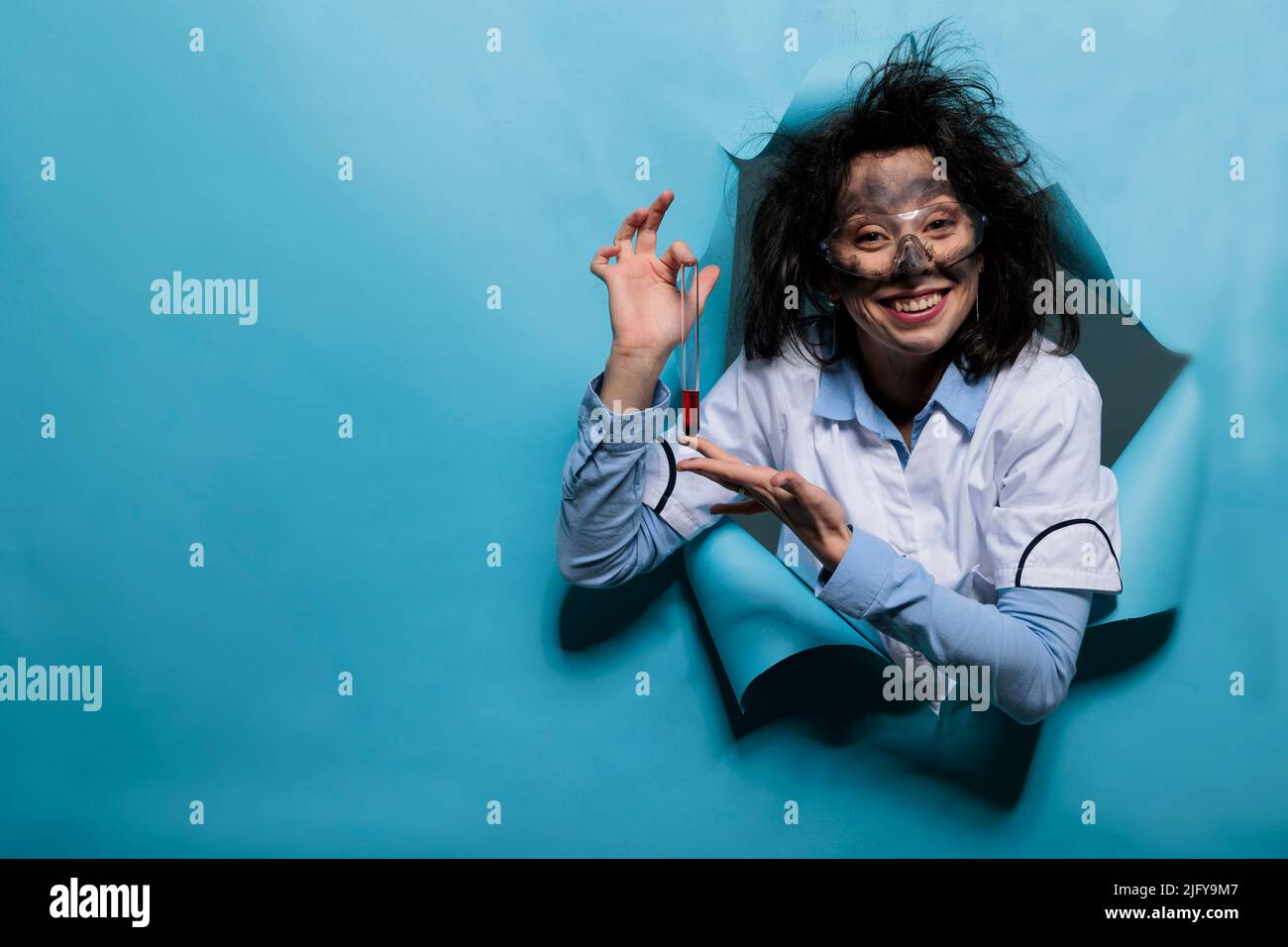 Crazy mad chemist with funny face expression holding flask filled with ...