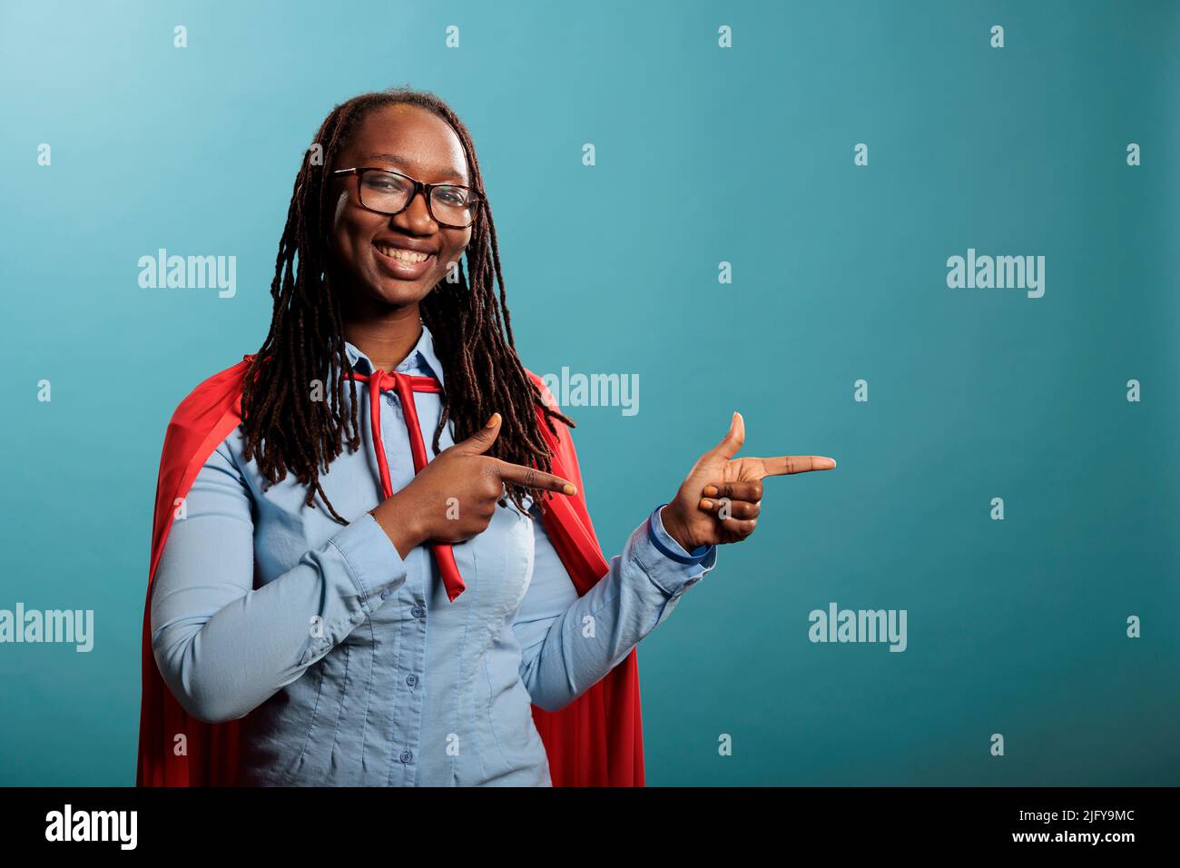 Portrait of young adult african american superhero woman poiting ...