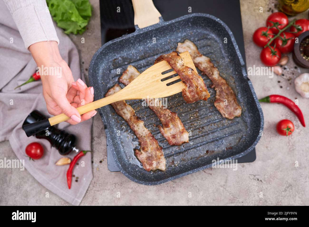 Bacon Being Cooked in grill frying pan Skillet at domestic kitchen ...