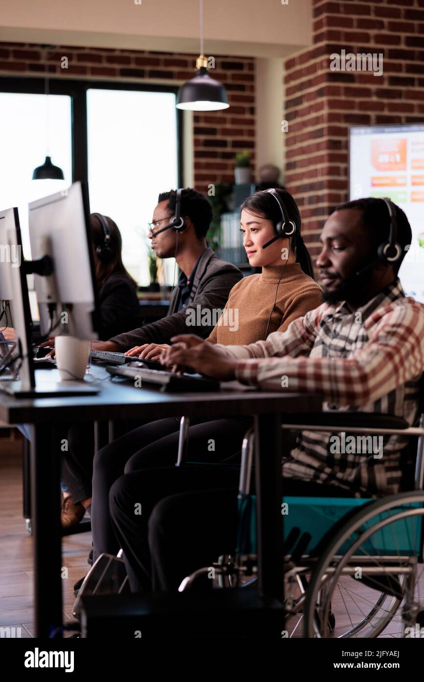 Paralyzed wheelchair user working at call center helpline reception ...