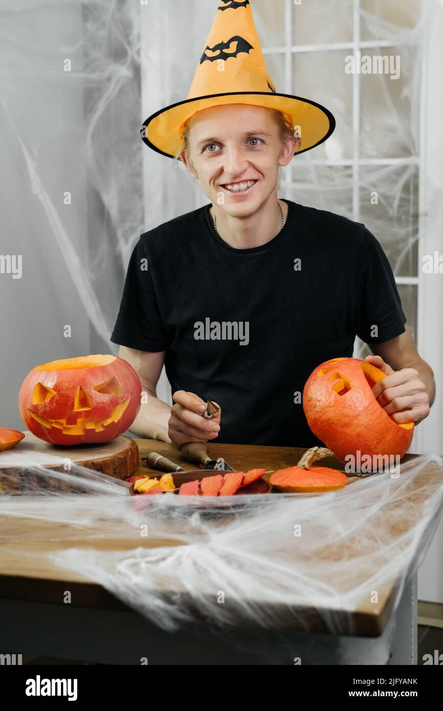 Man curving jac o lanten Helloween pumpkin at home. Getting ready for ...