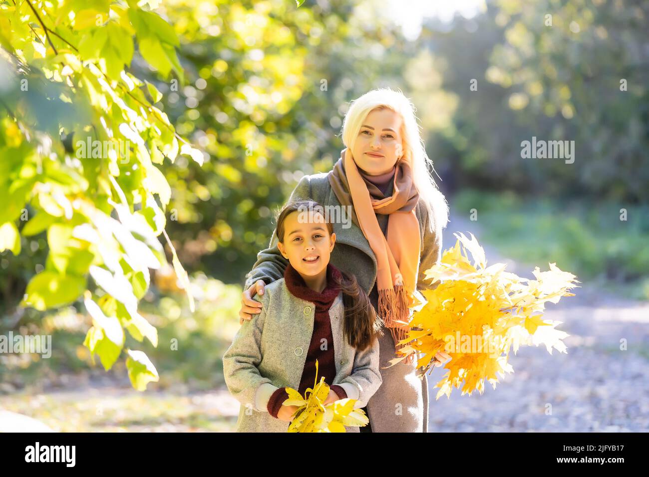 happy family: mother and child little daughter play on autumn walk in ...
