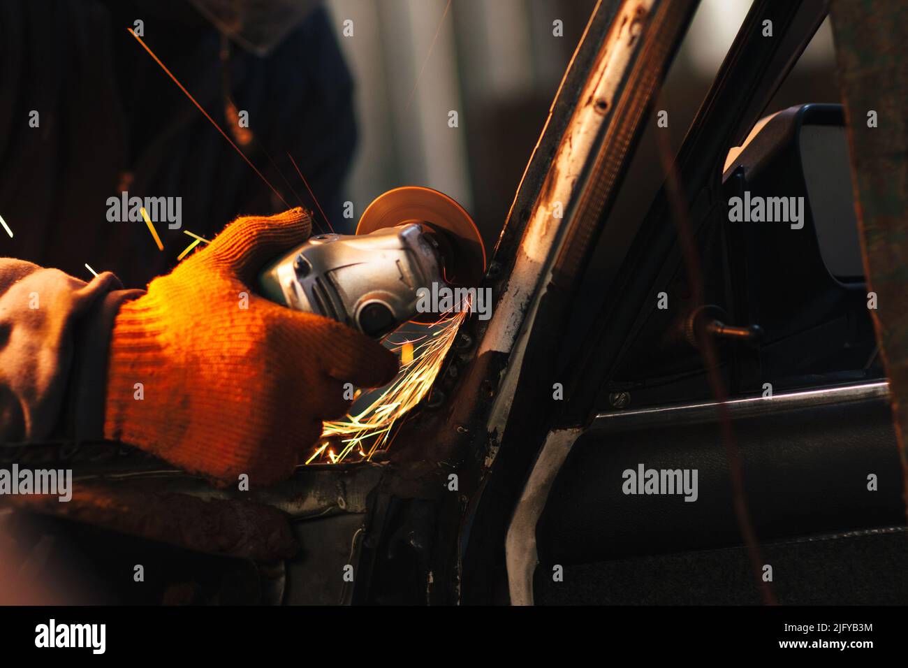 Craftsman repair a car with angle grinder Stock Photo - Alamy