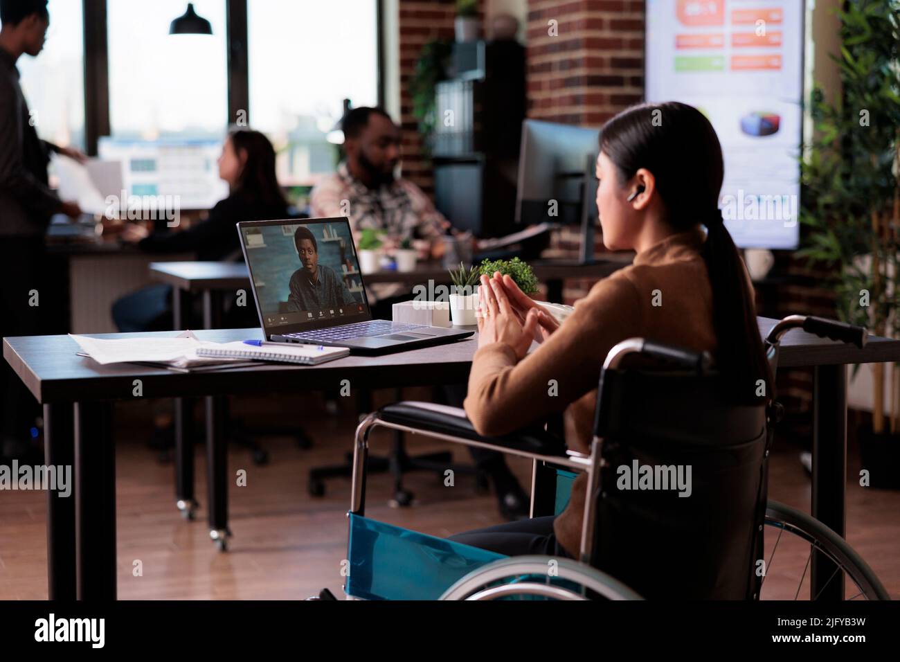 Employee with physical disability talking on online videocall, meeting ...