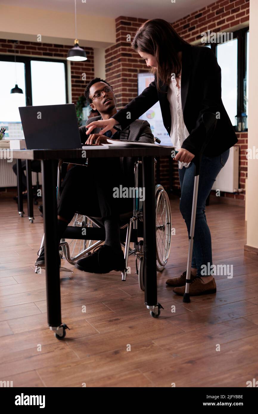 Multiethnic team of businesspeople with chronic impairment working on ...