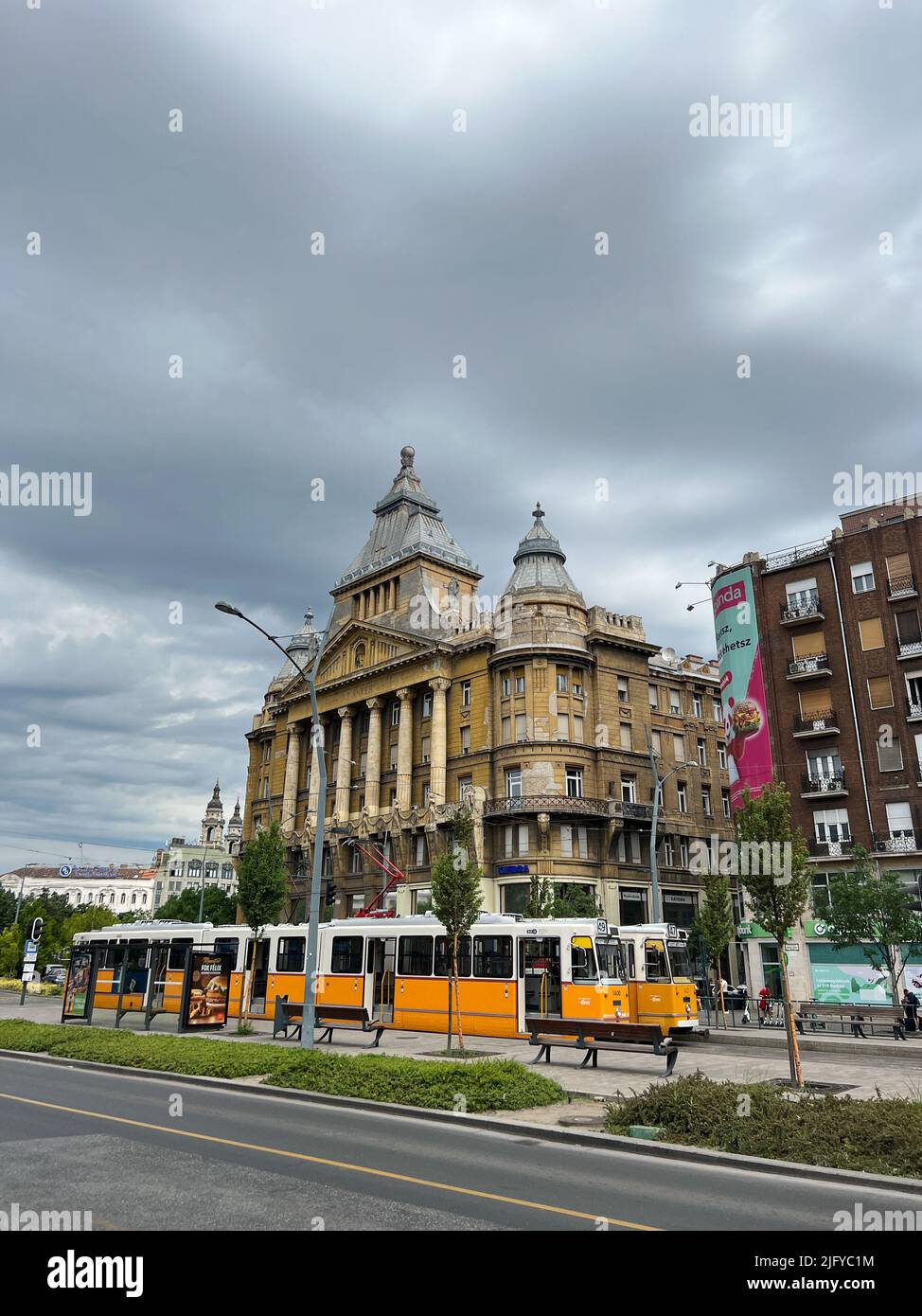 Yellow trams stand on Deak Ferenc Square near Anker house. Budapest ...