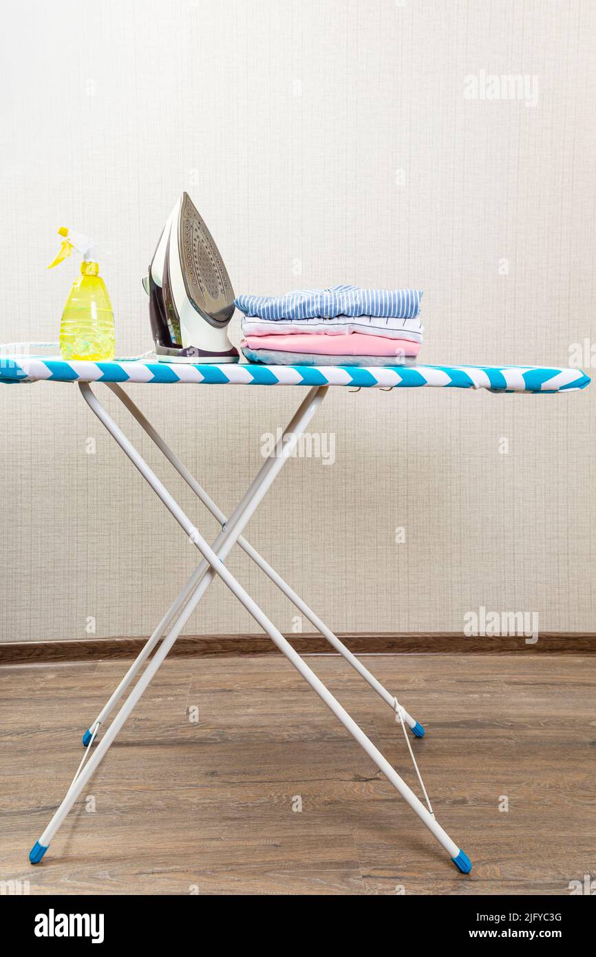 Electric iron on ironing board and water spray for ironing Stock Photo ...