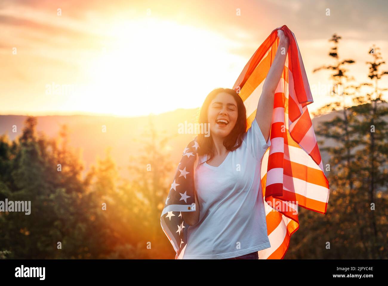 Independence day. A happy caucasian young woman has risen an American ...