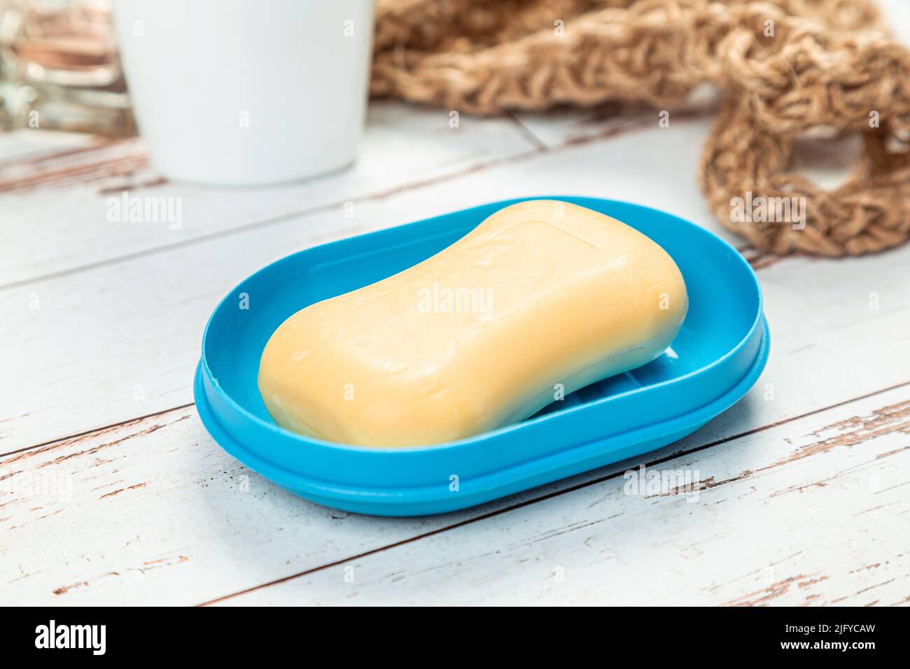 soap on a blue soap dish isolated on a wooden table. hygiene ...