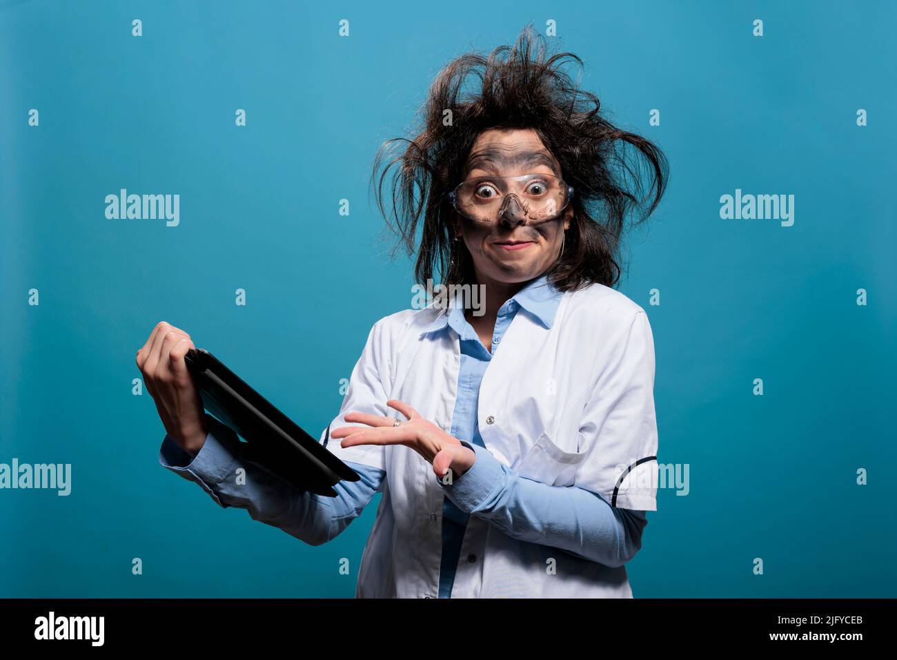 Mad chemist having touchscreen tablet and confused expression with ...