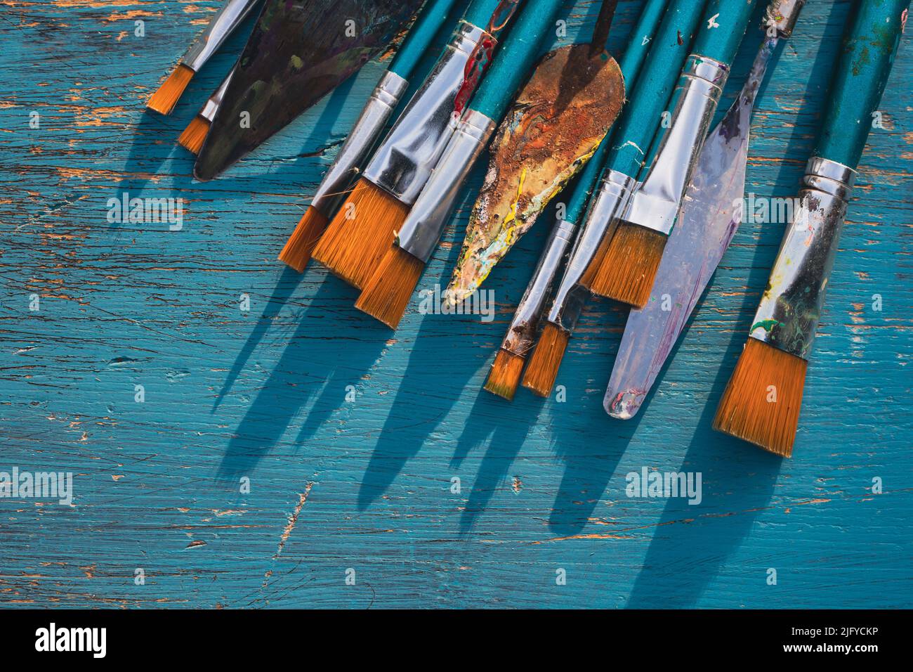 Artistic art supply utensils with paintbrushes on turquoise wooden ...