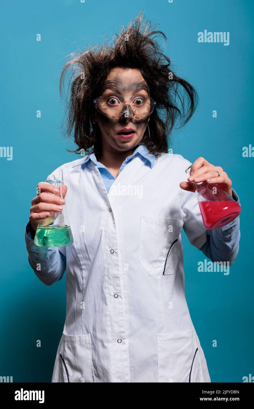 Surprised crazy chemistry specialist holding glass beakers filled with ...