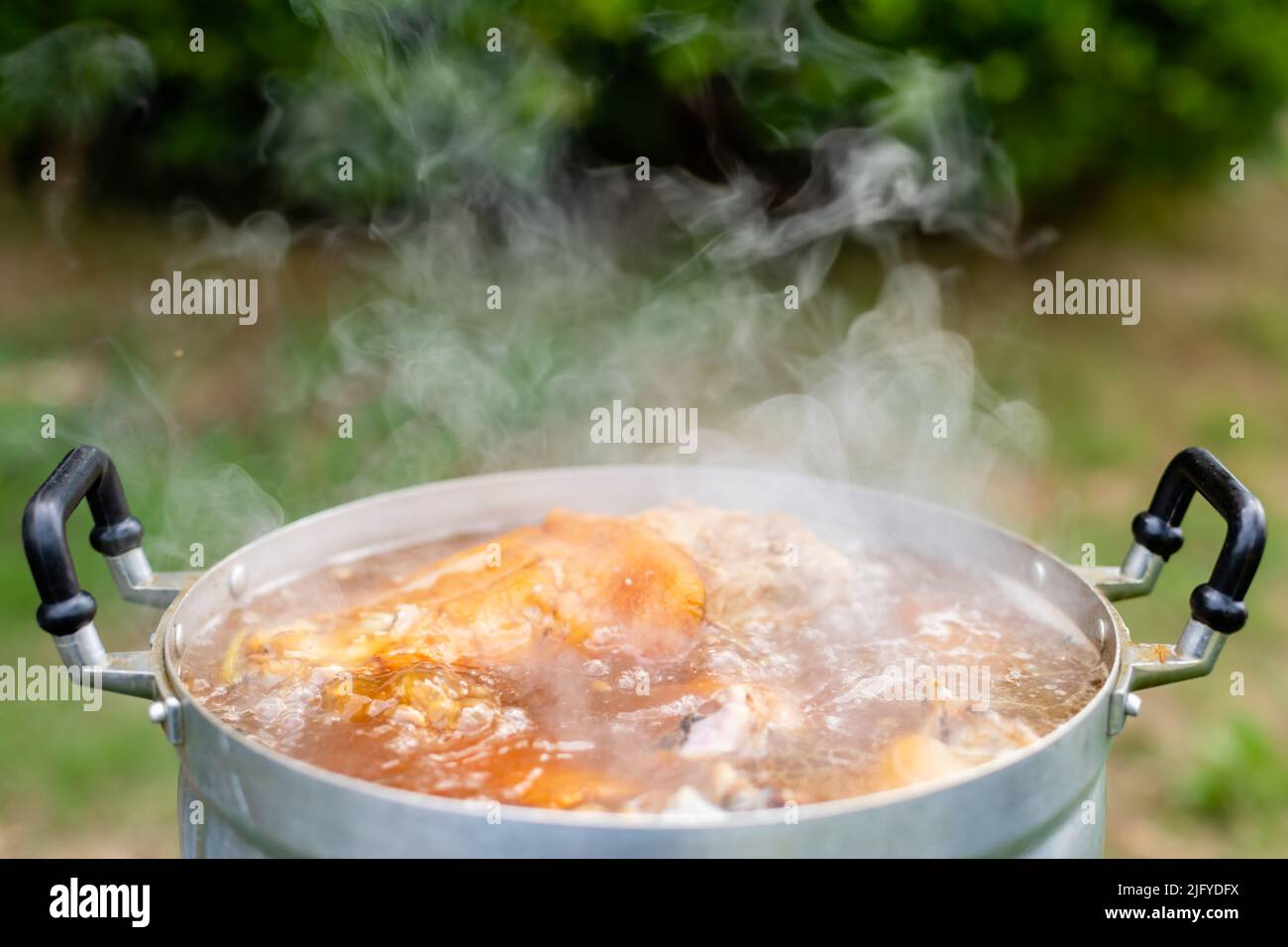 Close up stewed pork leg in silver pot on stove. Thai style food and ...