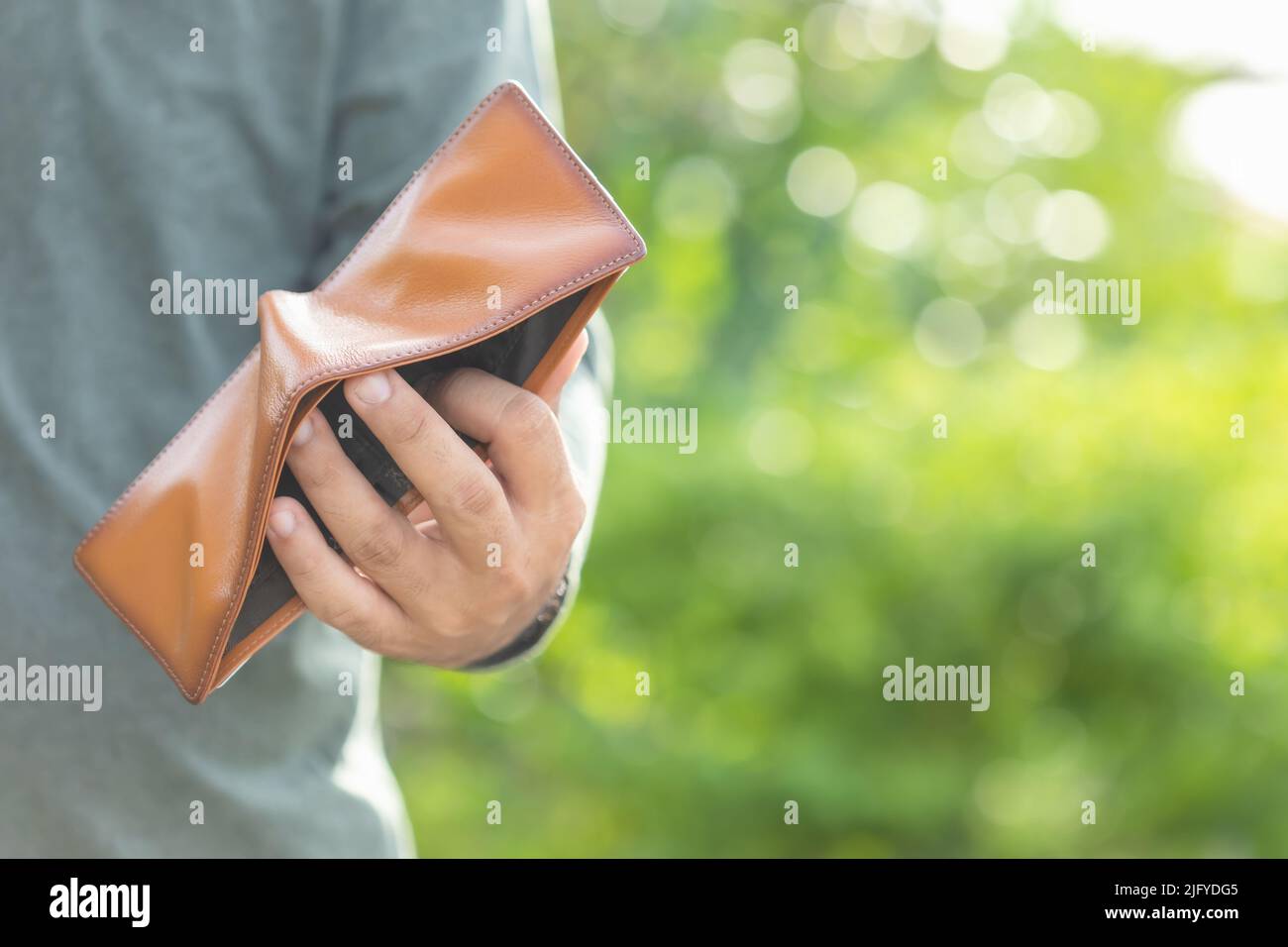 Asian man holding empty wallet. Money problem concept. Outdoor shooting ...