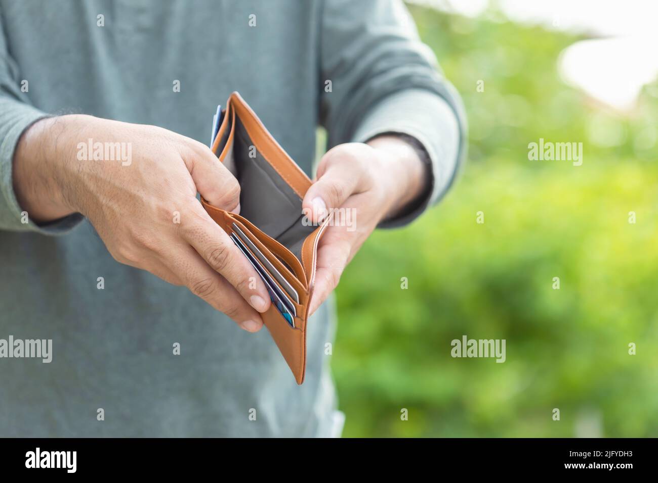 Asian man holding empty wallet. Money problem concept. Outdoor shooting ...