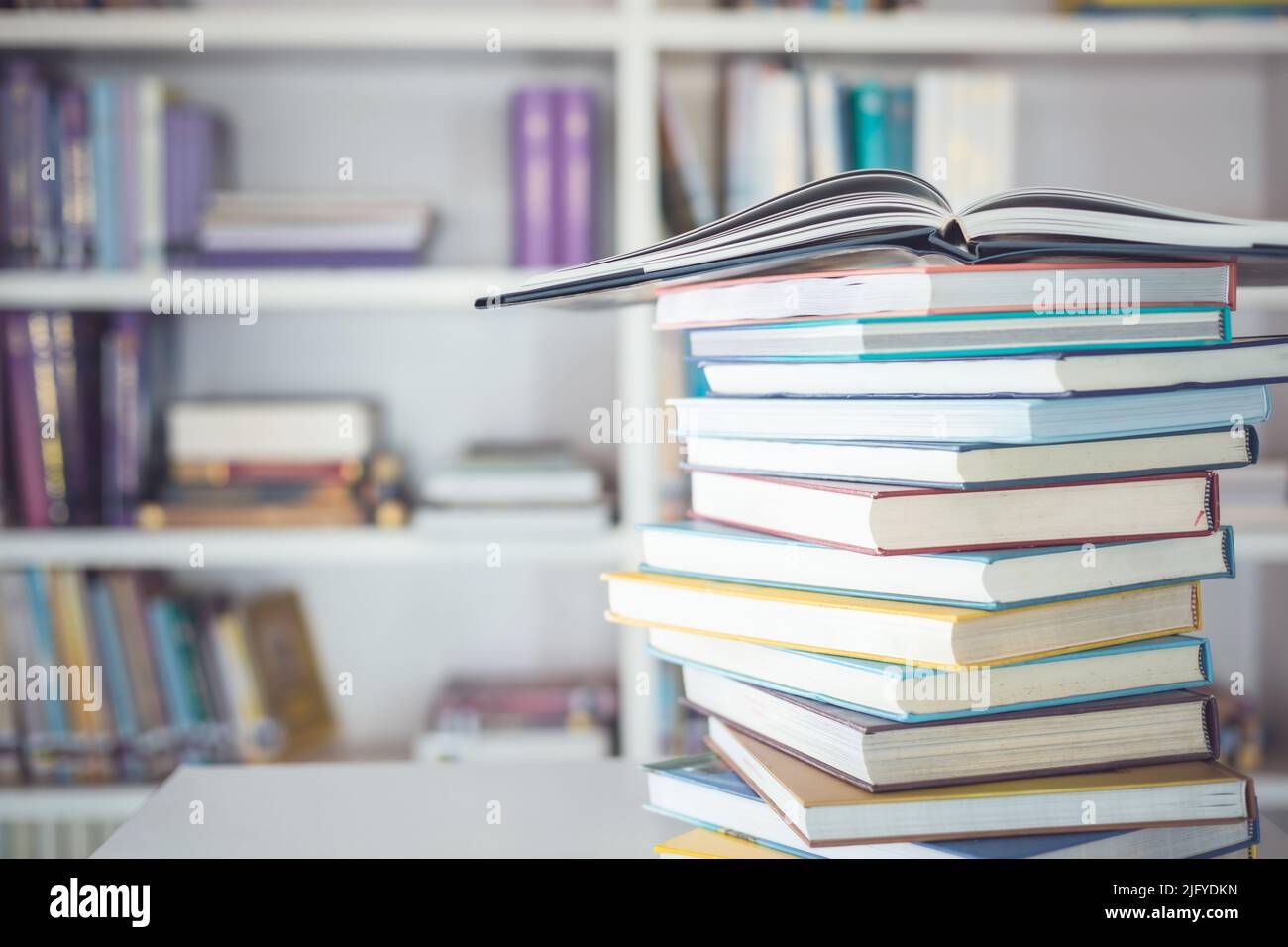 Close up book stack on the table in the library room and blurred space ...