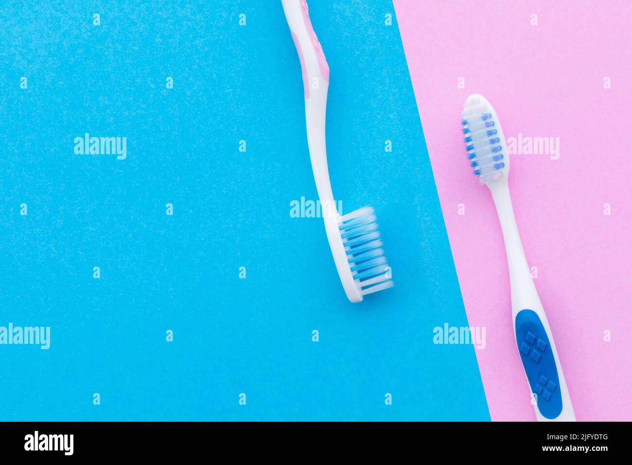 Top view new pink and blue toothbrush on pink background with copy ...
