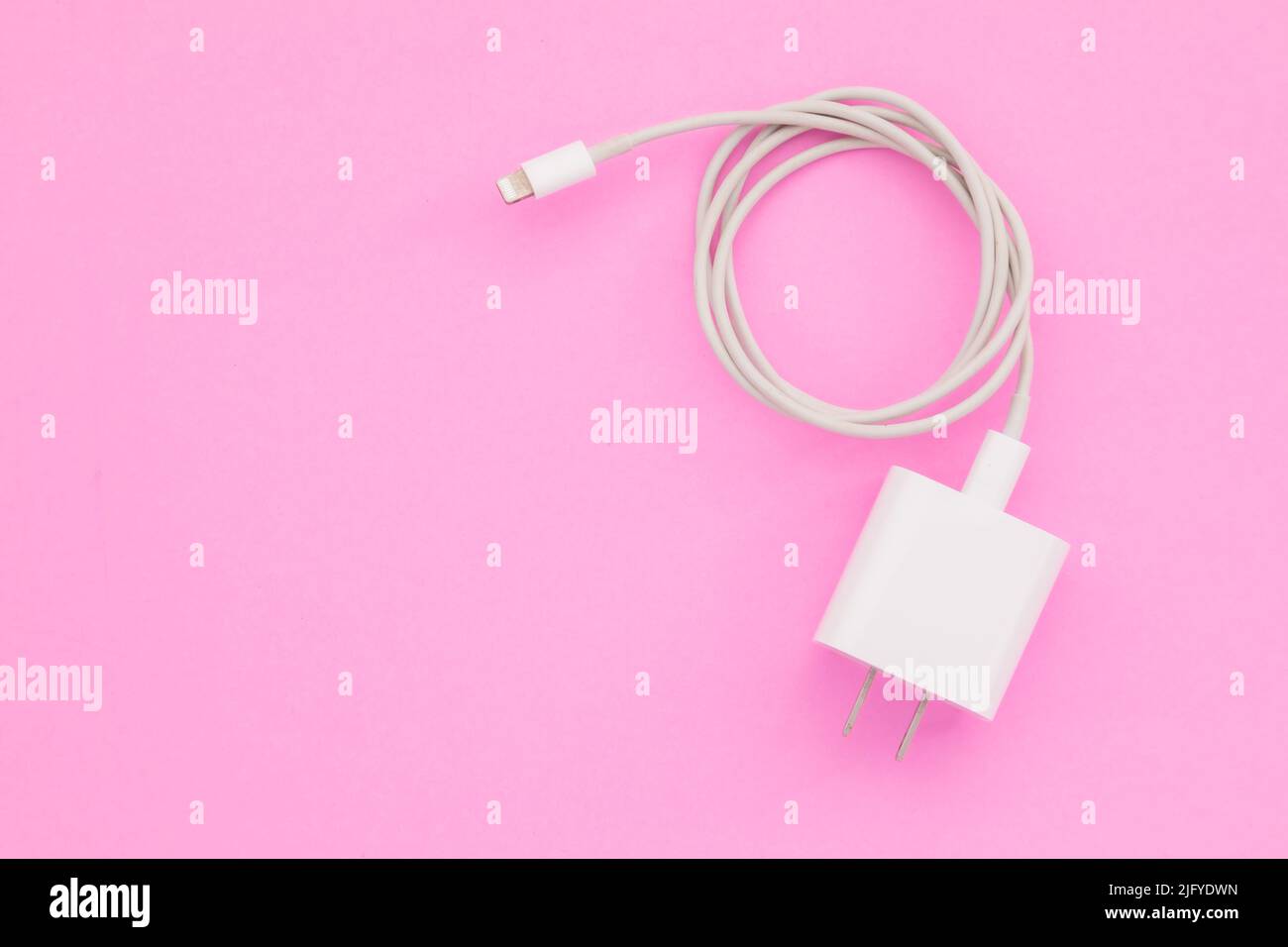 Top view new white smartphone charger on pink background with copy ...