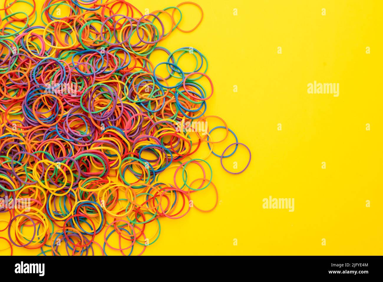Top view Elastic band rubber, multicolor rubber bands on yellow ...
