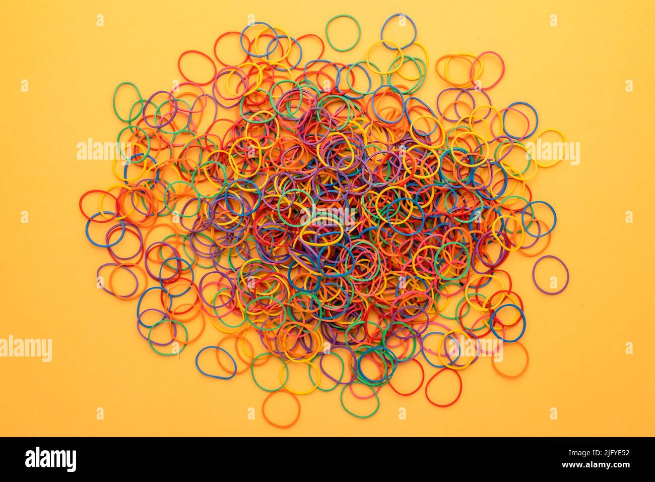 Top view Elastic band rubber, multicolor rubber bands on yellow ...