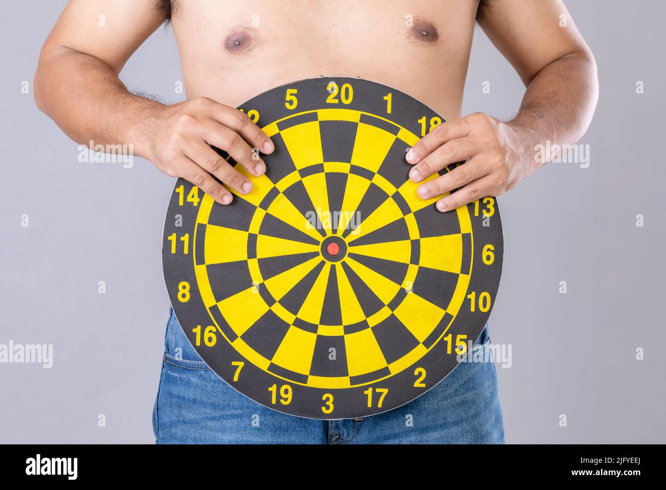 Fat people holding round yellow dartboard beside his belly position ...