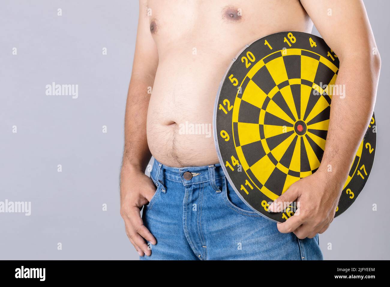 Fat people holding round yellow dartboard beside his belly position ...